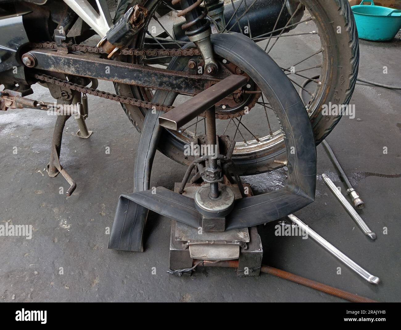 A motorcycle whose rear tire is being punctured and patched with ...