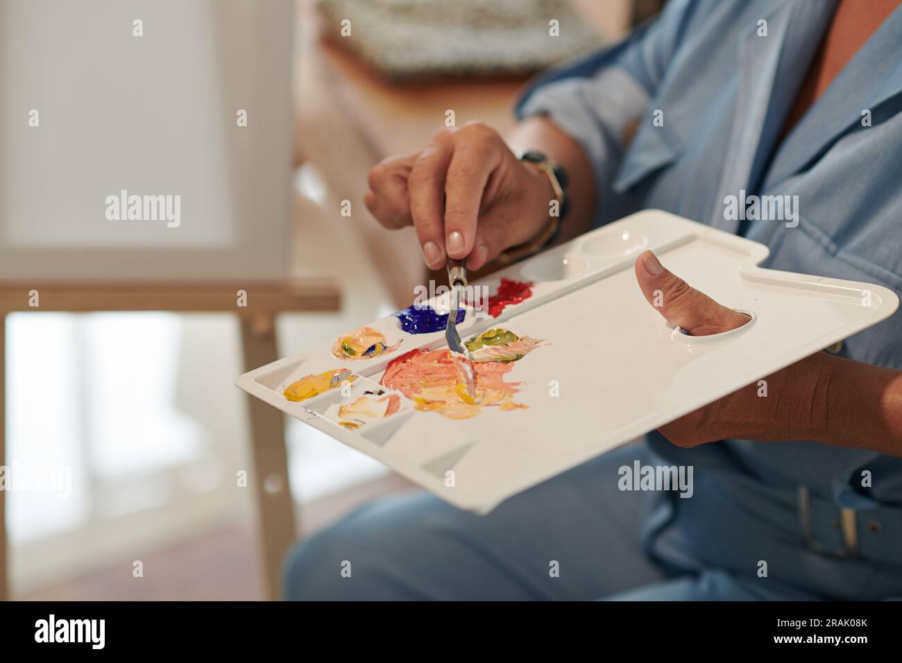 Closeup image of woman mixing colors on plastic palette Stock Photo - Alamy