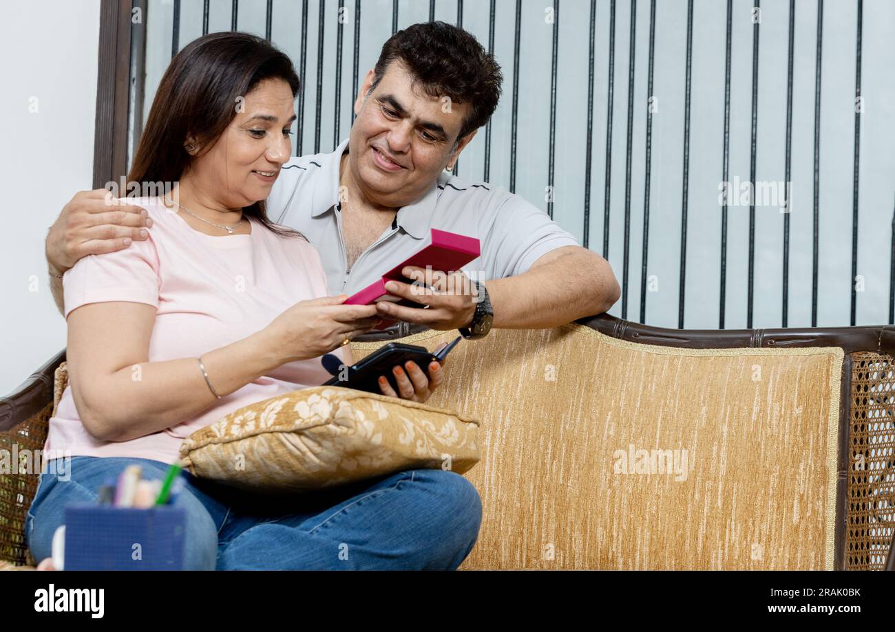 Indian husband covering his wife eyes, making birthday surprise, giving ...