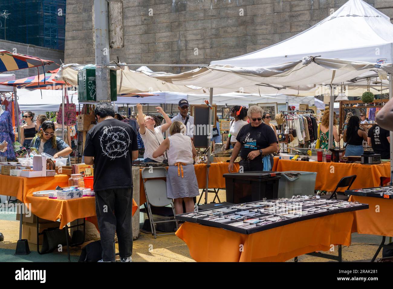 Shoppers browse second-hand merchandise at a flea market in the ...