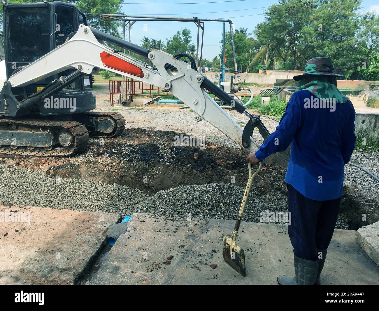 Construction worker steering a backhoe to renovate the site in ...