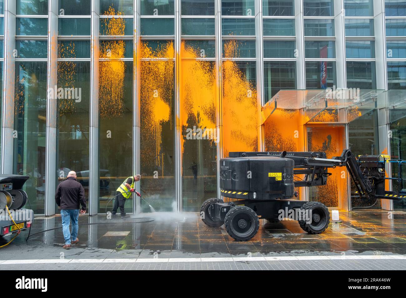 London- June 2023: Cleaning orange paint from building in Canary Wharf ...