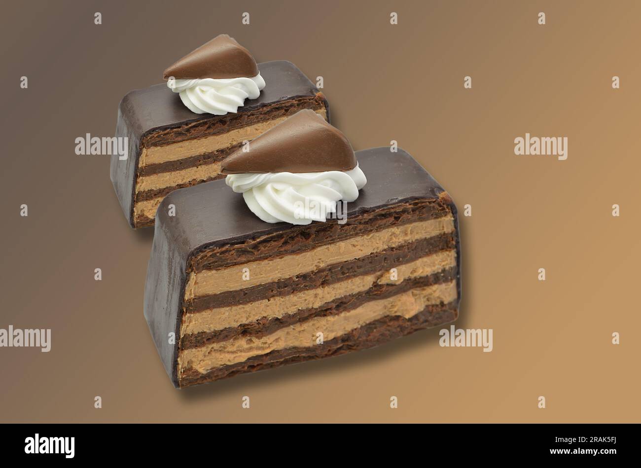 two pieces of chocolate fancy cake on brown background with colour ...