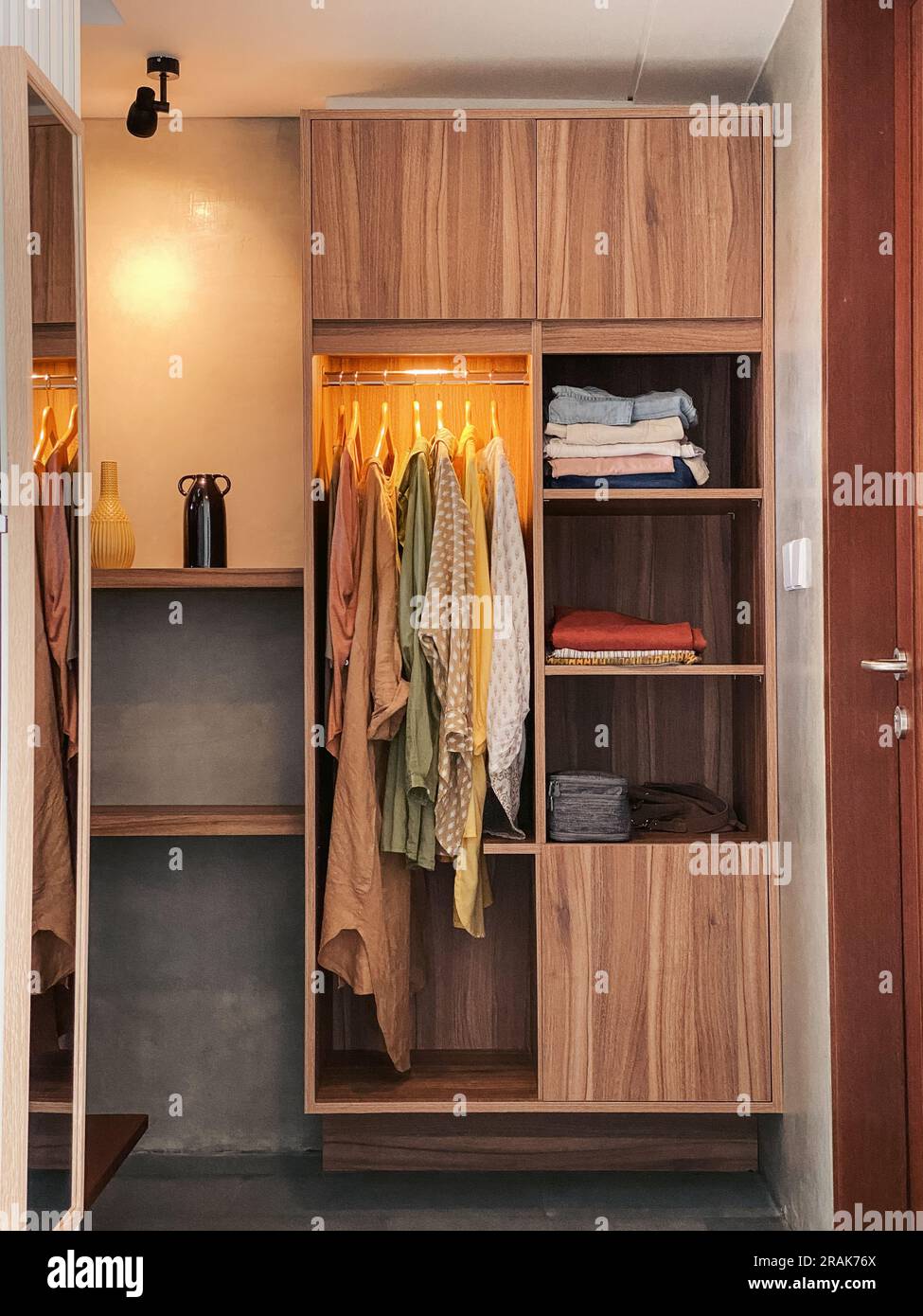 Wardrobe with clothes and a mirror in a stylish dressing room Stock ...