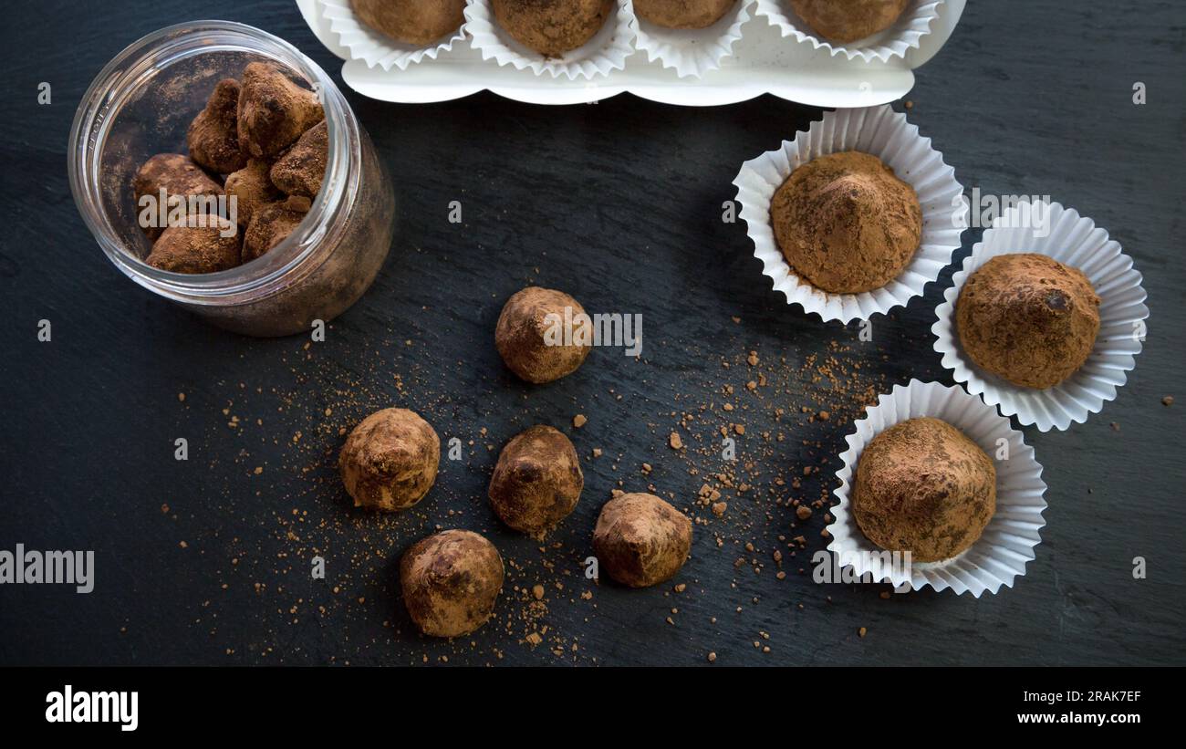 Truffle candies liberally sprinkled with cocoa in white substrates on a ...