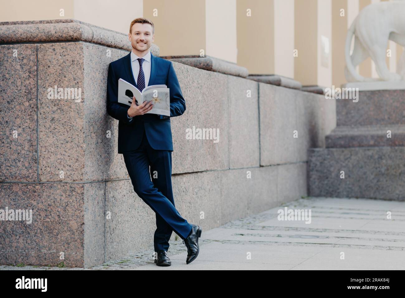 Successful boss prepares for presentation, holds magazine, reads ...