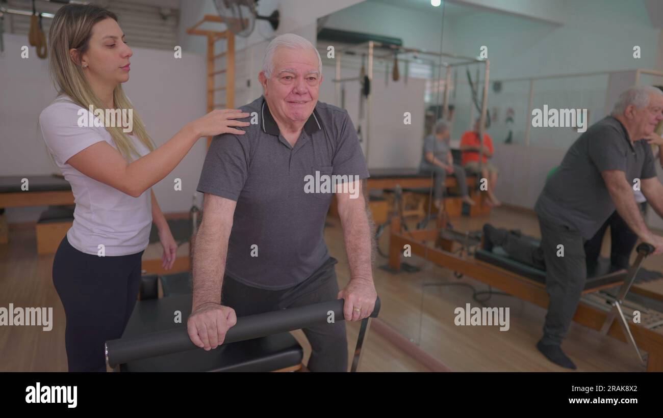 Elderly Man Focusing on Spine Health, Stretching with Machine Under ...
