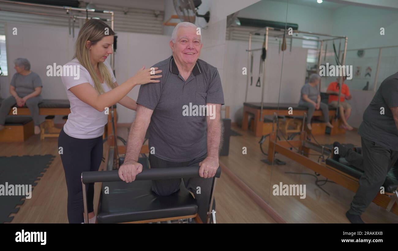 Elderly Man Focusing on Spine Health, Stretching with Machine Under ...