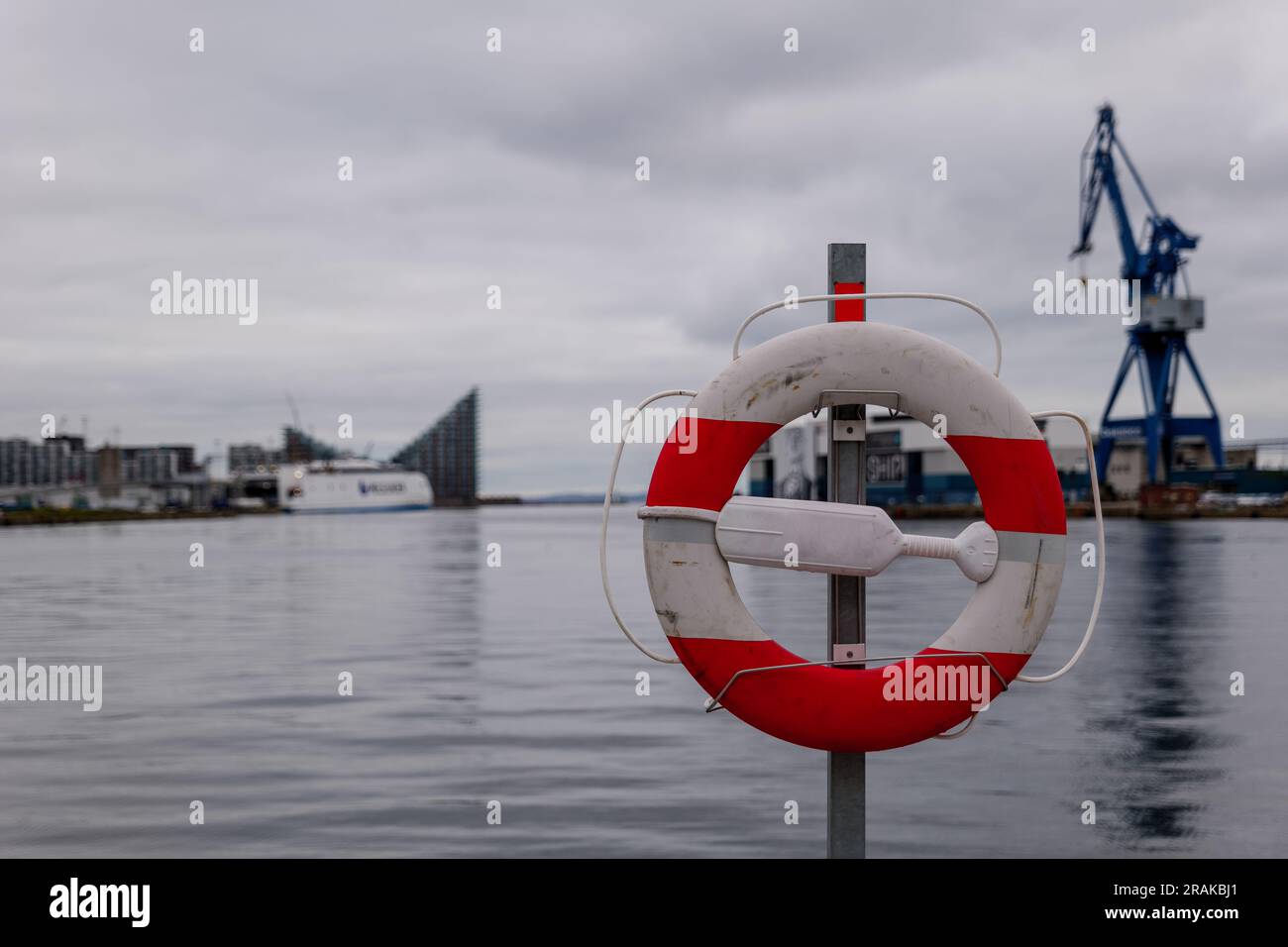 Selective focus at lifebuoy hang on the post on the waterside at the ...