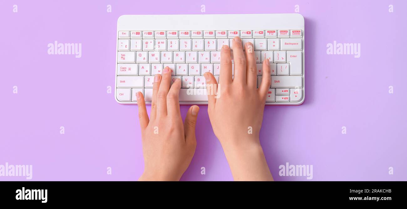 Hands with modern computer keyboard on lilac background Stock Photo - Alamy