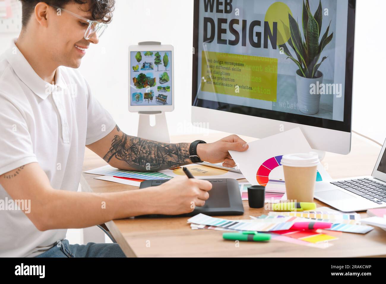 Male graphic designer working with tablet and color palette in office ...