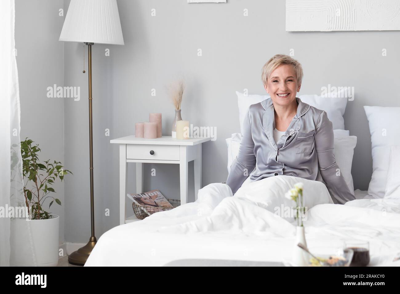 Mature woman waking up in bedroom Stock Photo - Alamy