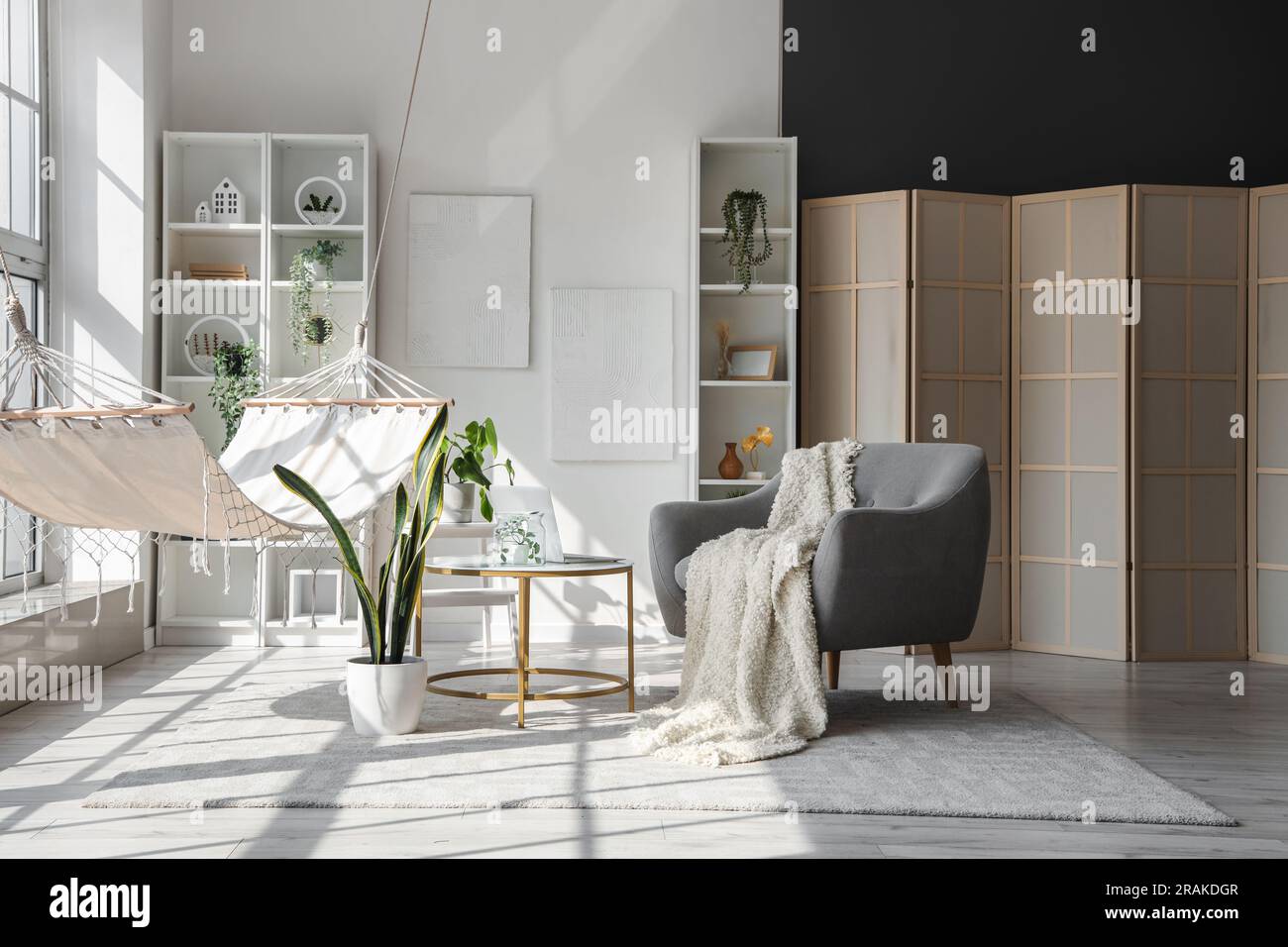 Interior of light living room with hammock, table and armchair Stock ...