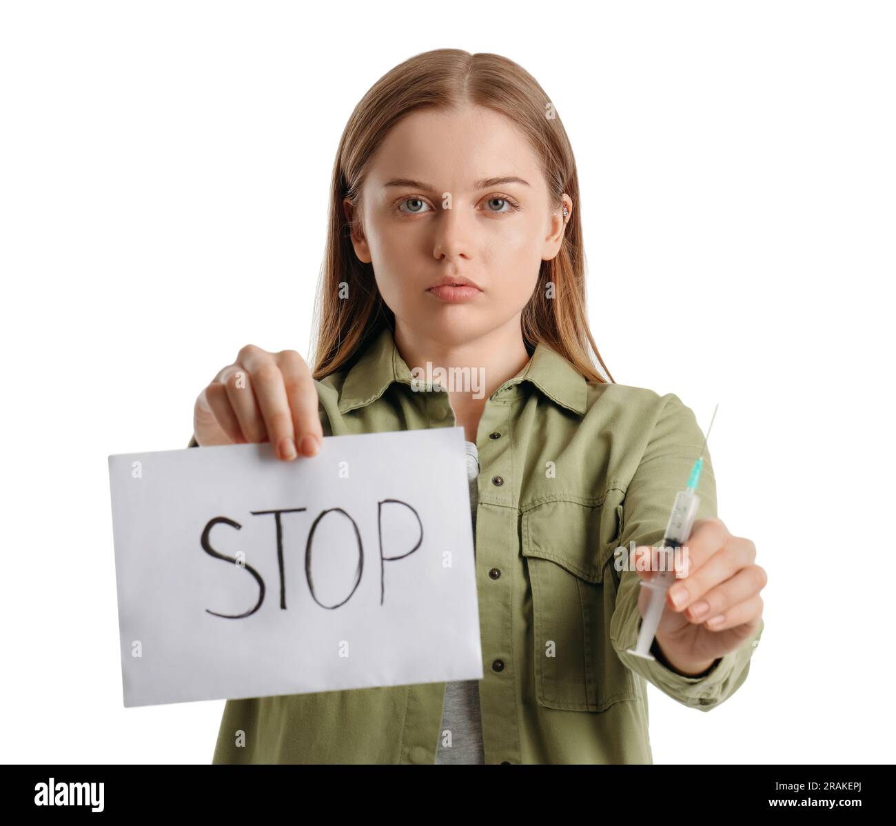 Young female junkie holding syringe and paper with word STOP on white ...