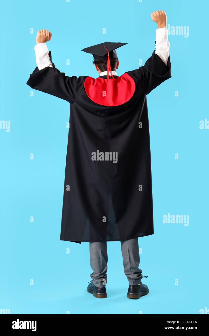 Happy male graduate student on blue background, back view Stock Photo ...