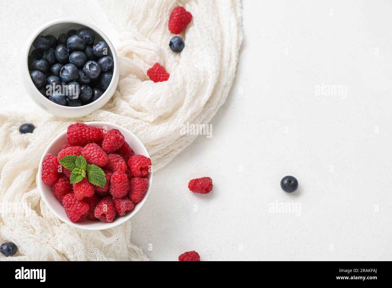Bowls with fresh raspberry and blueberry on light background Stock ...
