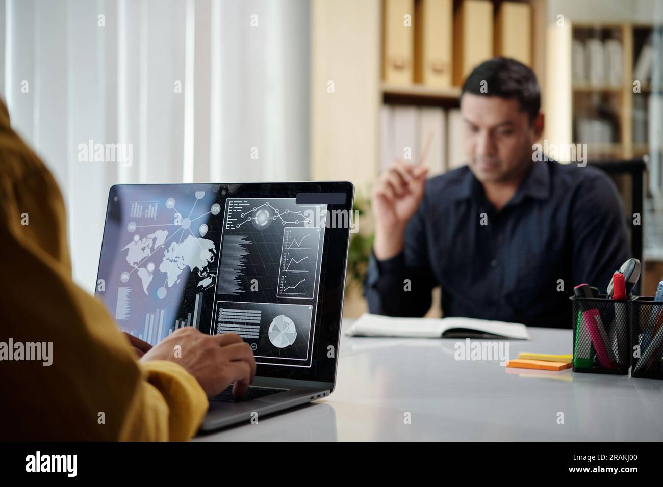 Marketing manager working on presentation of new product, coworker ...