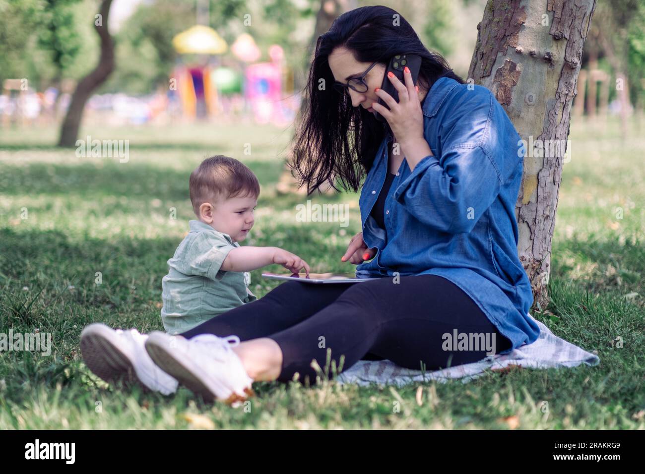 Baby boy pressing tablet screen and interfering mother conversation by ...