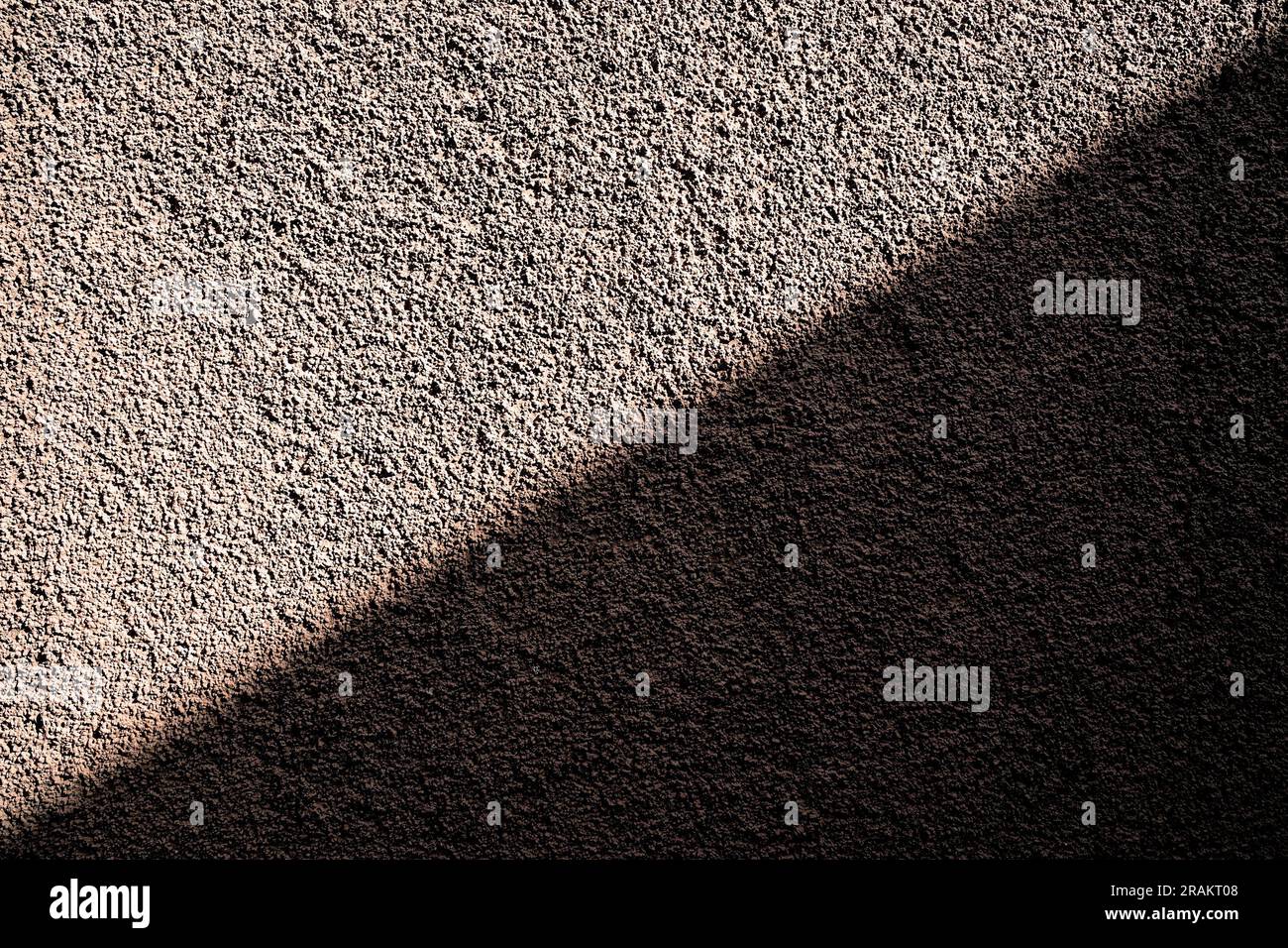 Bronze textured background split diagonally into brightly lit and shade ...