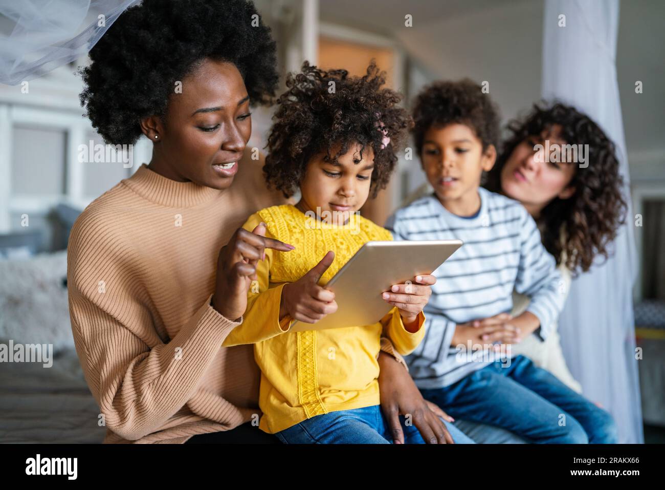 Happy multiethnic family having fun with digital device at home. Family ...