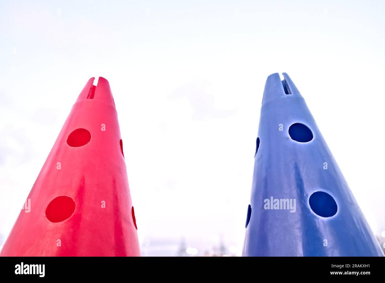 Tops of red and blue cones on pale sky background Stock Photo - Alamy