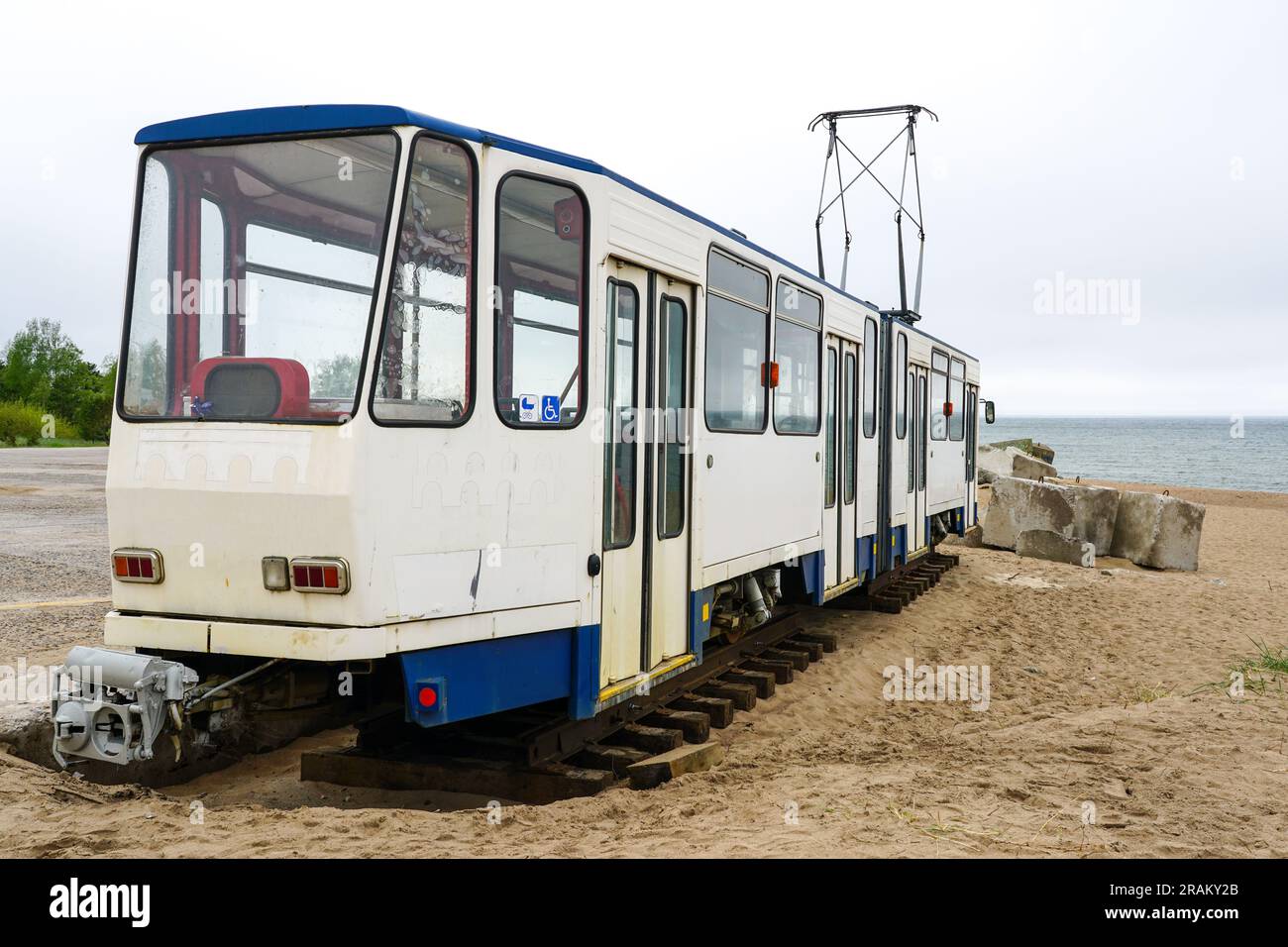 A used white electric tram car on the shore of the Baltic Sea for ...