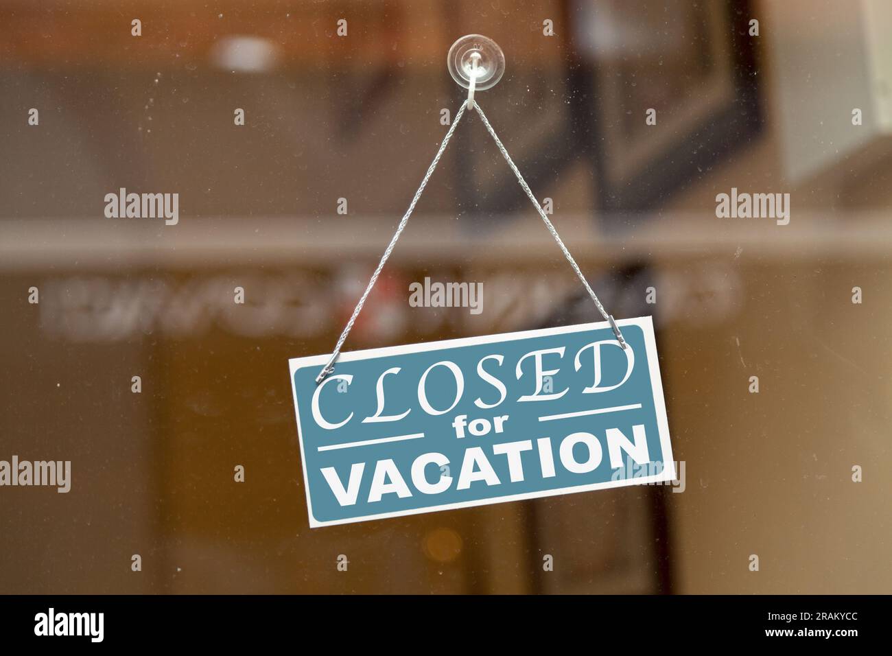 Blueish sign hanging at the glass door of a shop with written in it ...