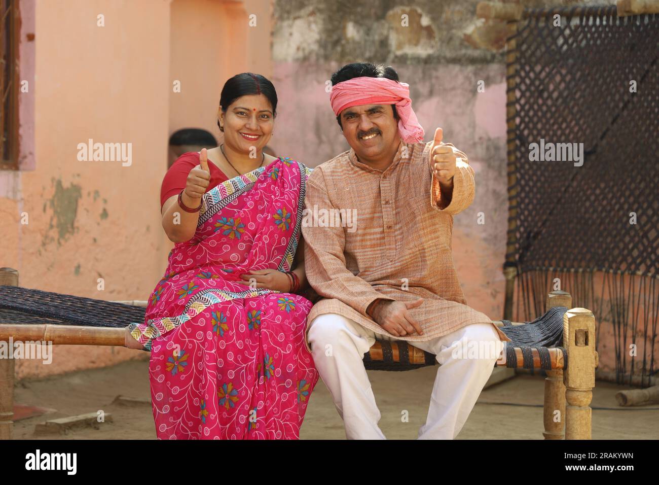 Happy Indian village family using the laptop sitting outside the house ...