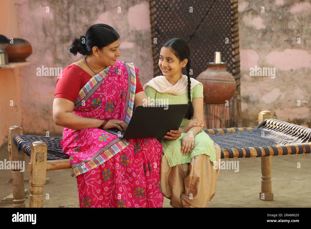 Happy Indian village family of single mother and daughter using laptop ...