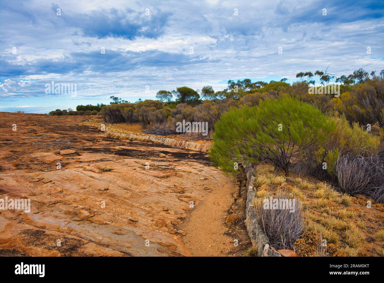 Low walls to guide rainwater from a granite outcrop in the outback to a ...