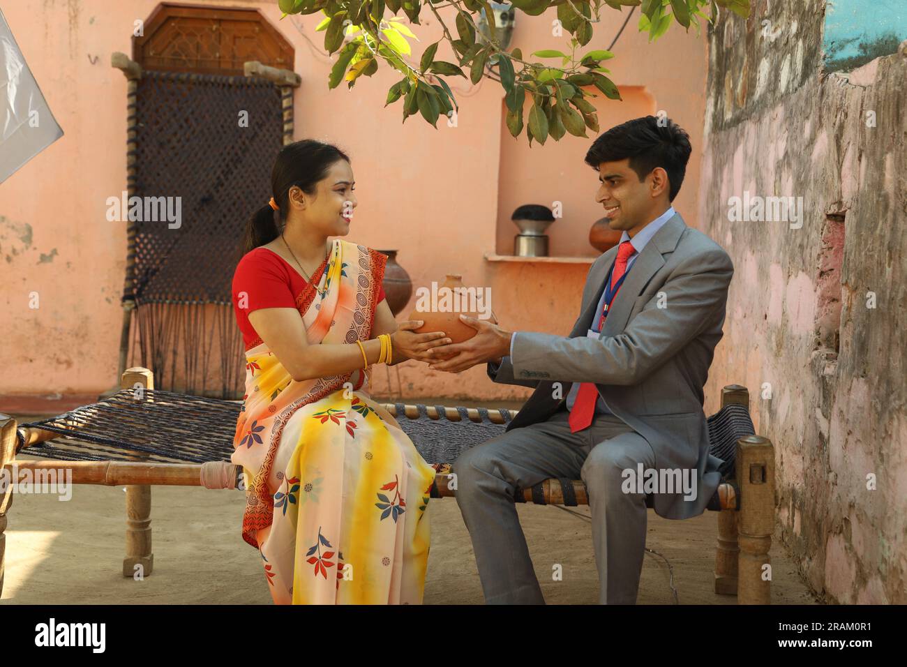 Happy rural Indian women sitting with insurance agent holding the Piggy ...