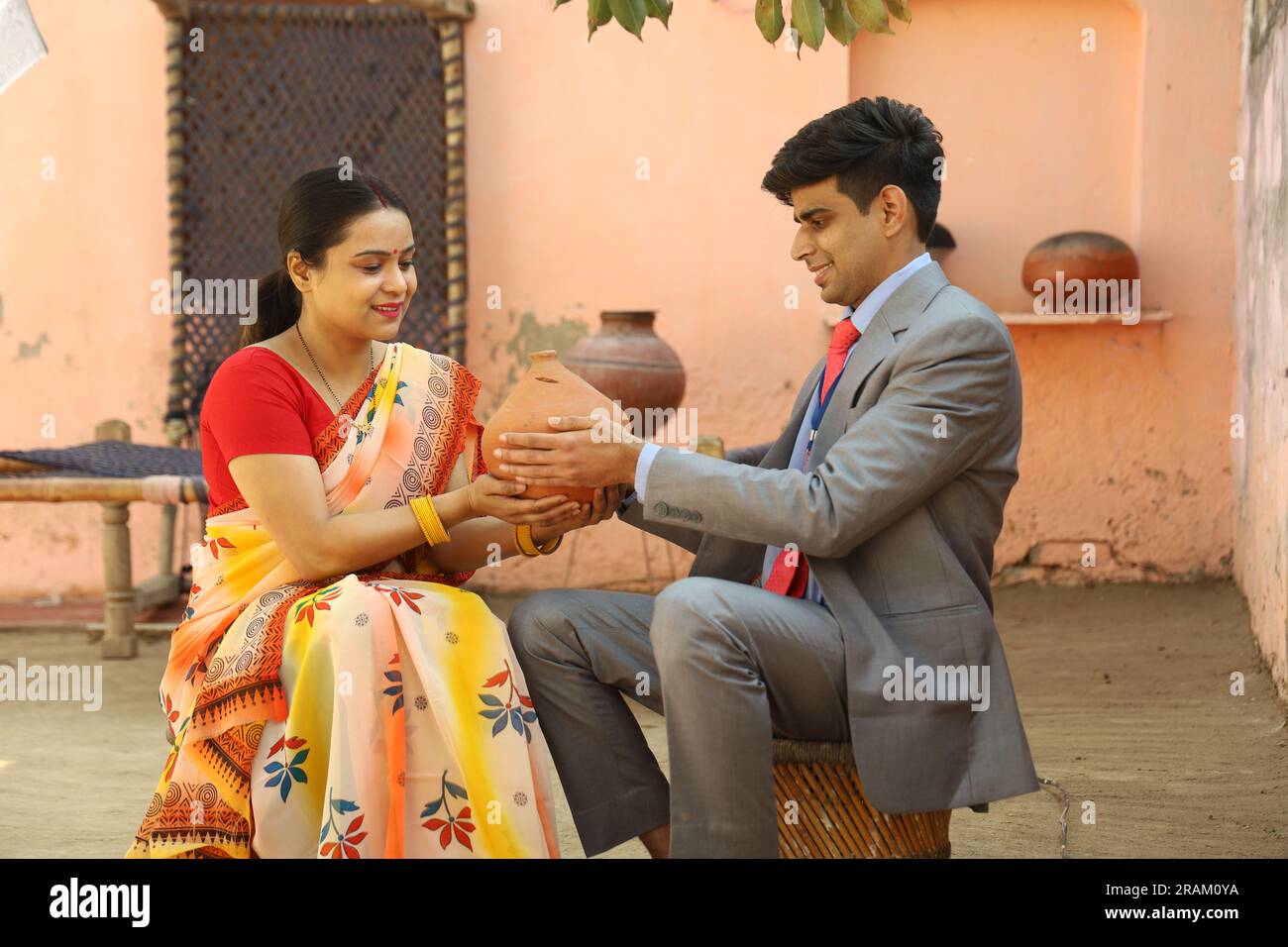Happy rural Indian women sitting with insurance agent holding the Piggy ...