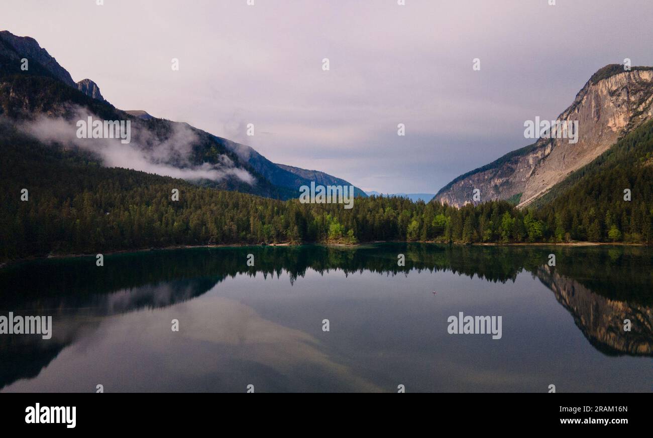 Drone footage of lake Tovel in the Dolemites during a cloudy morning ...