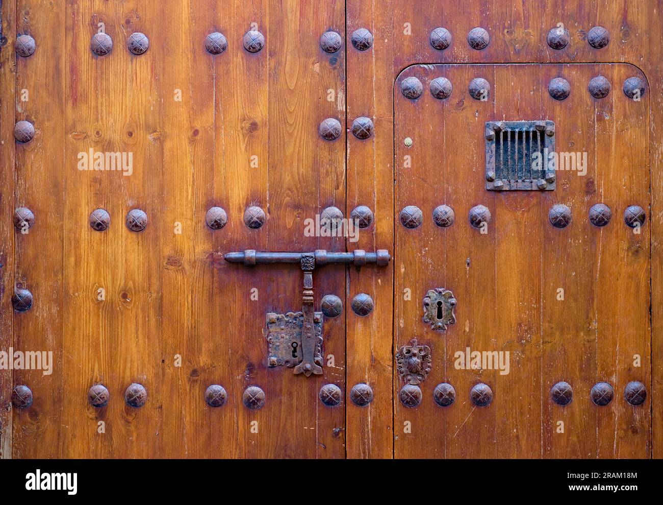 Locked up old decorative wooden door with a small peeping window Stock ...