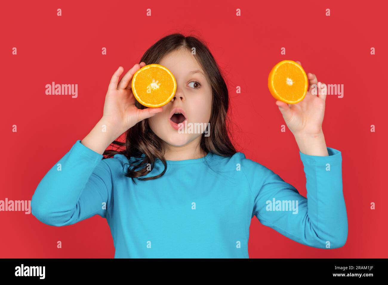 shocked teen child hold orange fruit on purple background Stock Photo ...