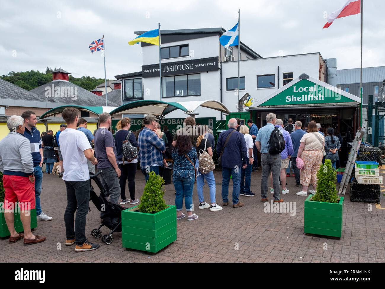 Customers queue at a shellfish stall at Oban ferry terminal, Oban ...