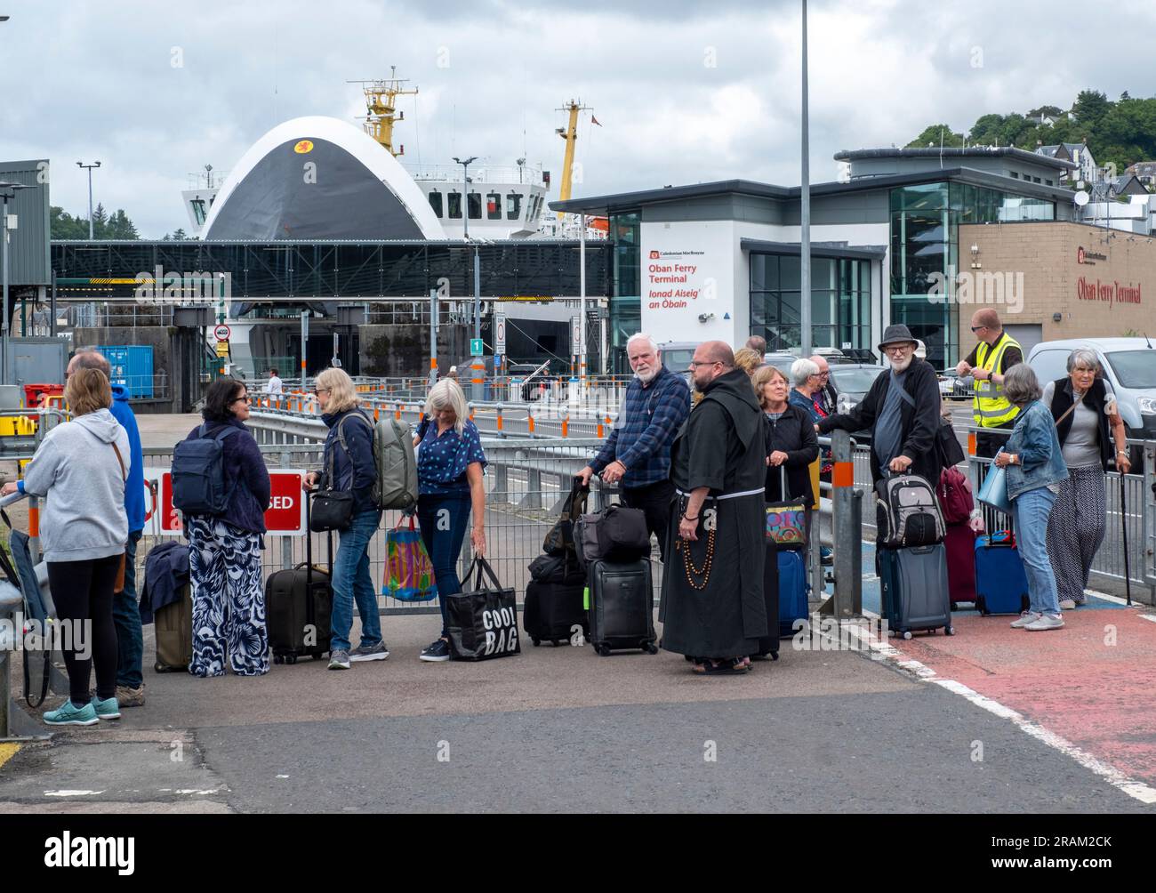 Foot passengers queue ready to board a ferry at Oban ferry terminal ...