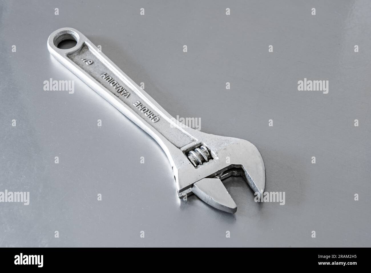 A hard steel spanner on a shiny gray surface Stock Photo - Alamy
