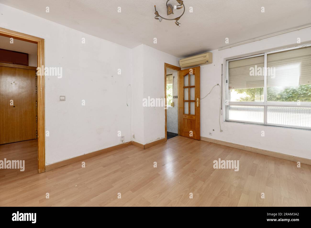 Empty living room with access door to several rooms, light wooden ...