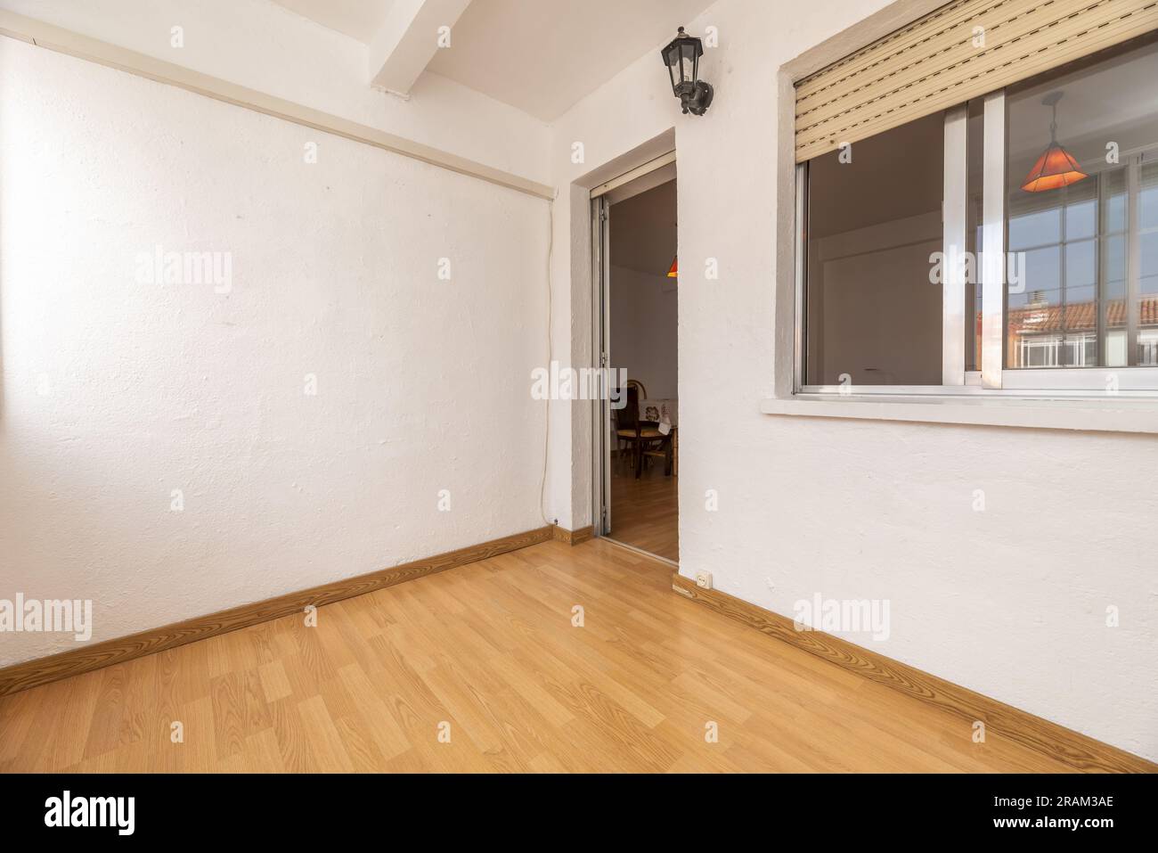 An empty enclosed terrace with double aluminum windows, a light wooden ...