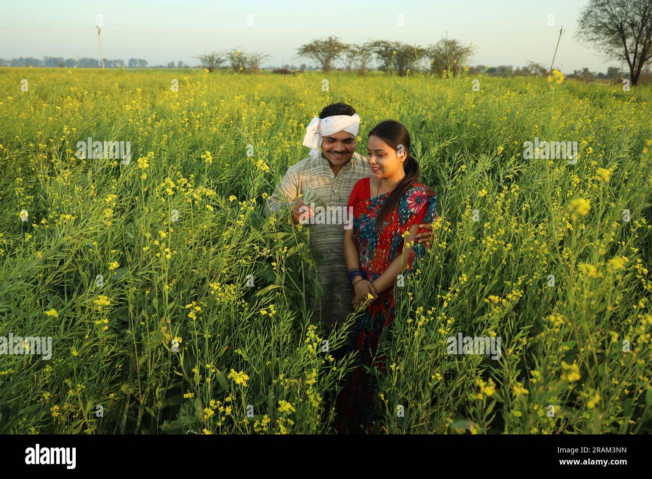 Happy Indian farmer couple standing in mustard field enjoying the ...