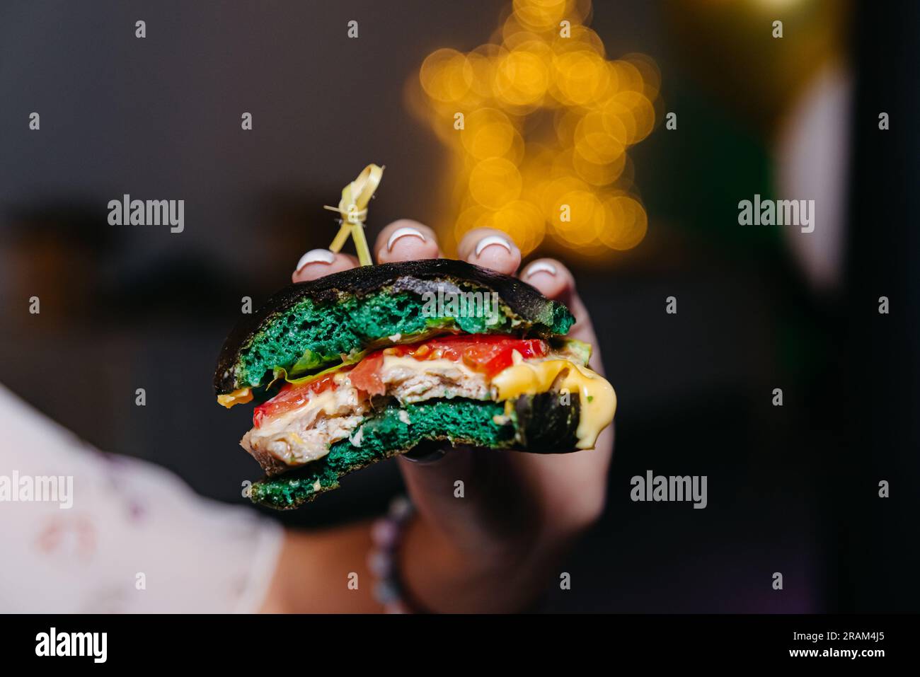 A person holding a bright colorful fast food item close up, the vibrant ...