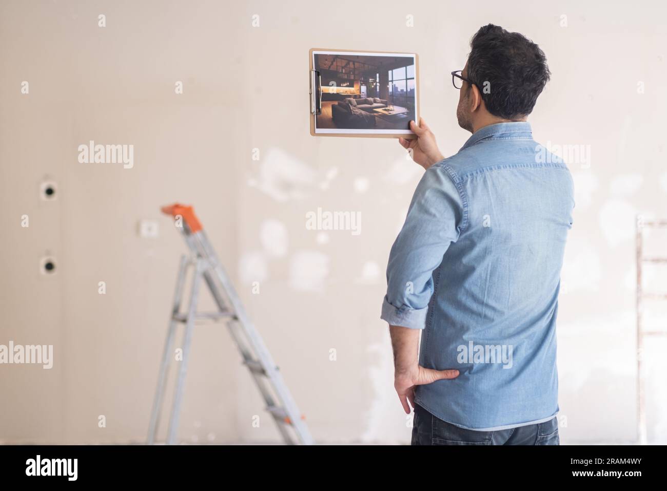 Man examining picture with loft-style interior design stands in ...