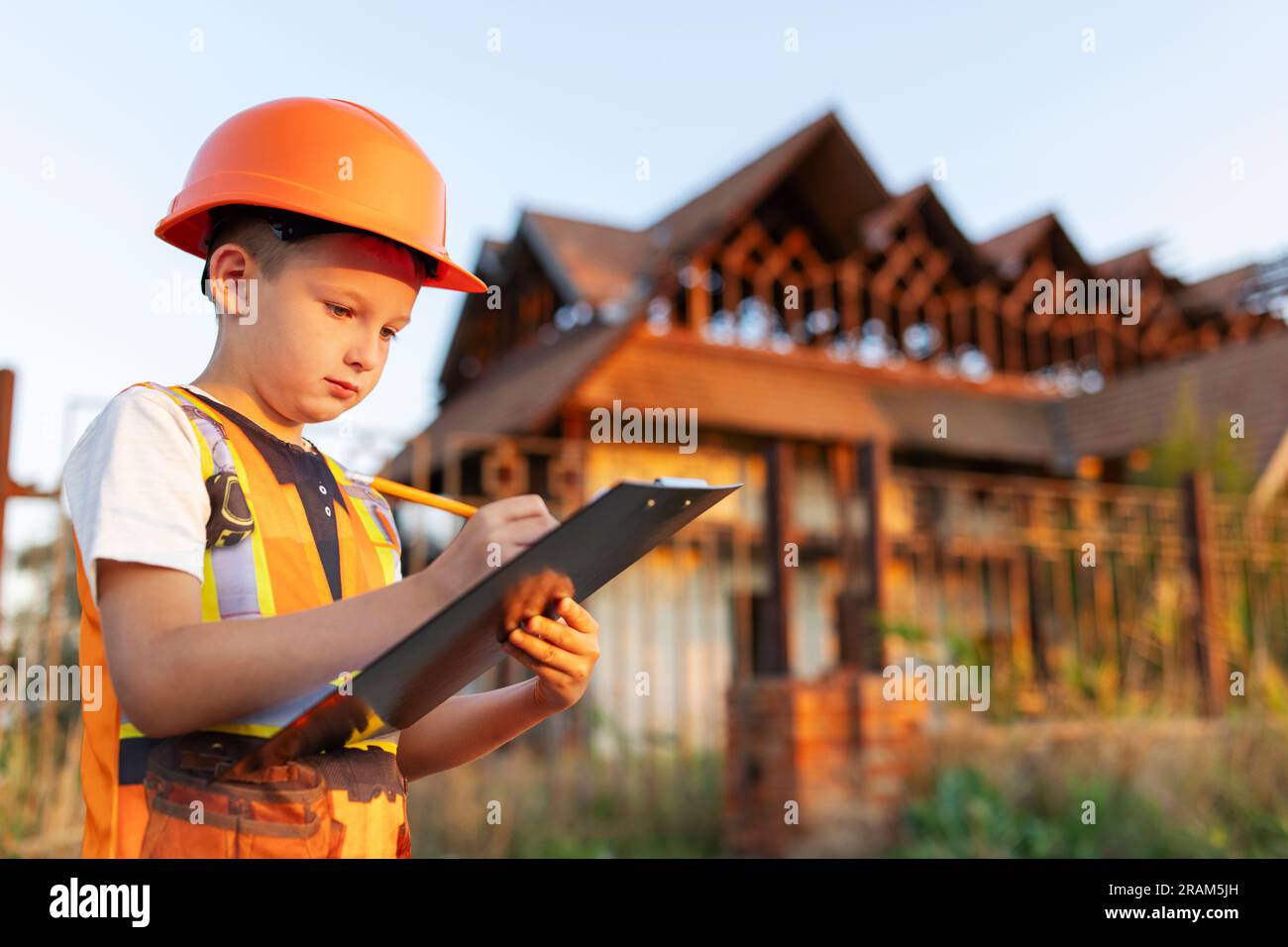 Child in a suit of an engineer is checking and inspecting the building ...