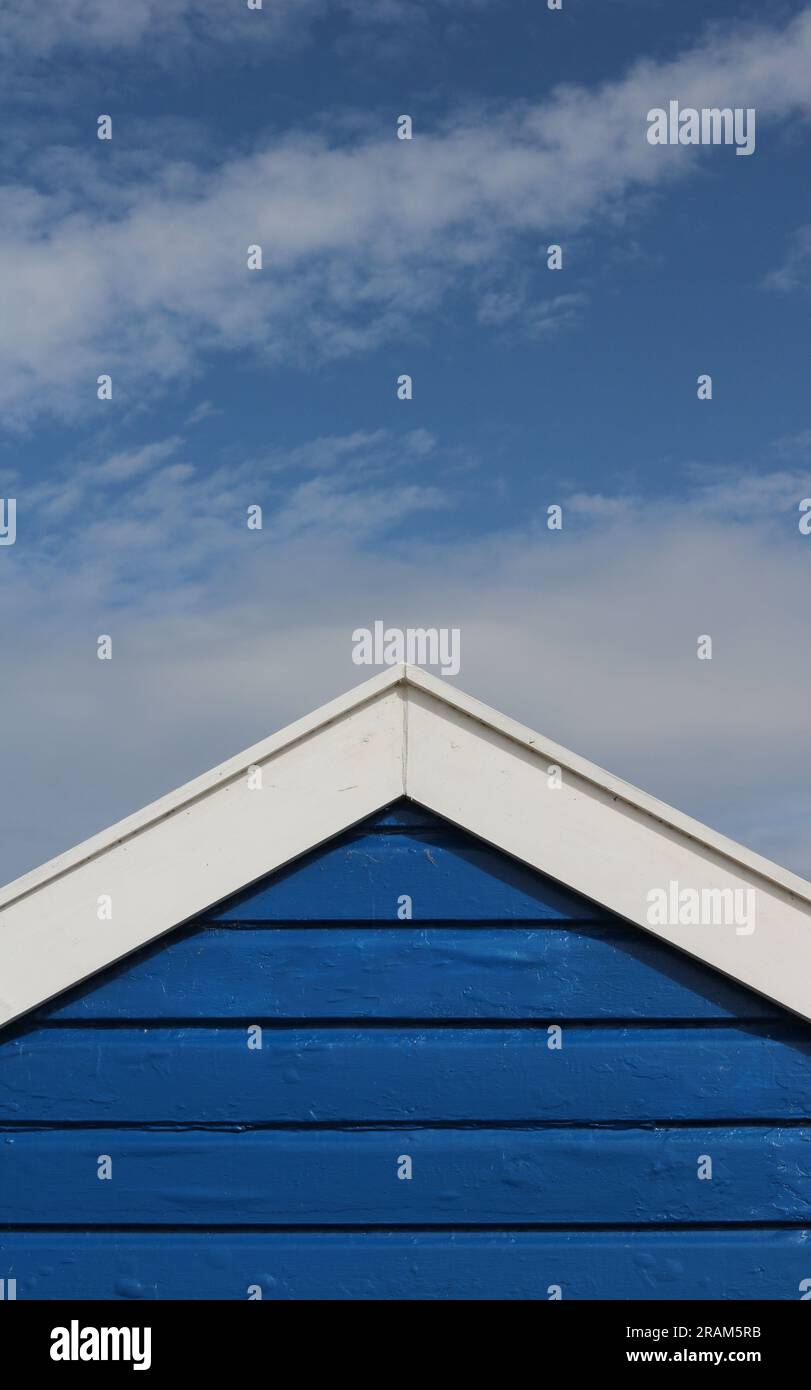 Vertical image of old English beach hut with pitched roof in blue and ...