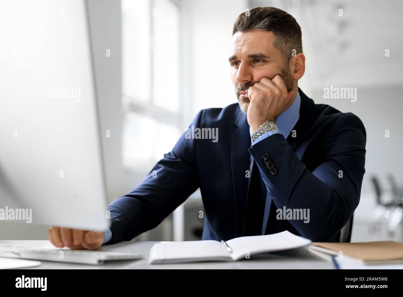 Bored middle aged businessman sitting in front of computer at workplace ...