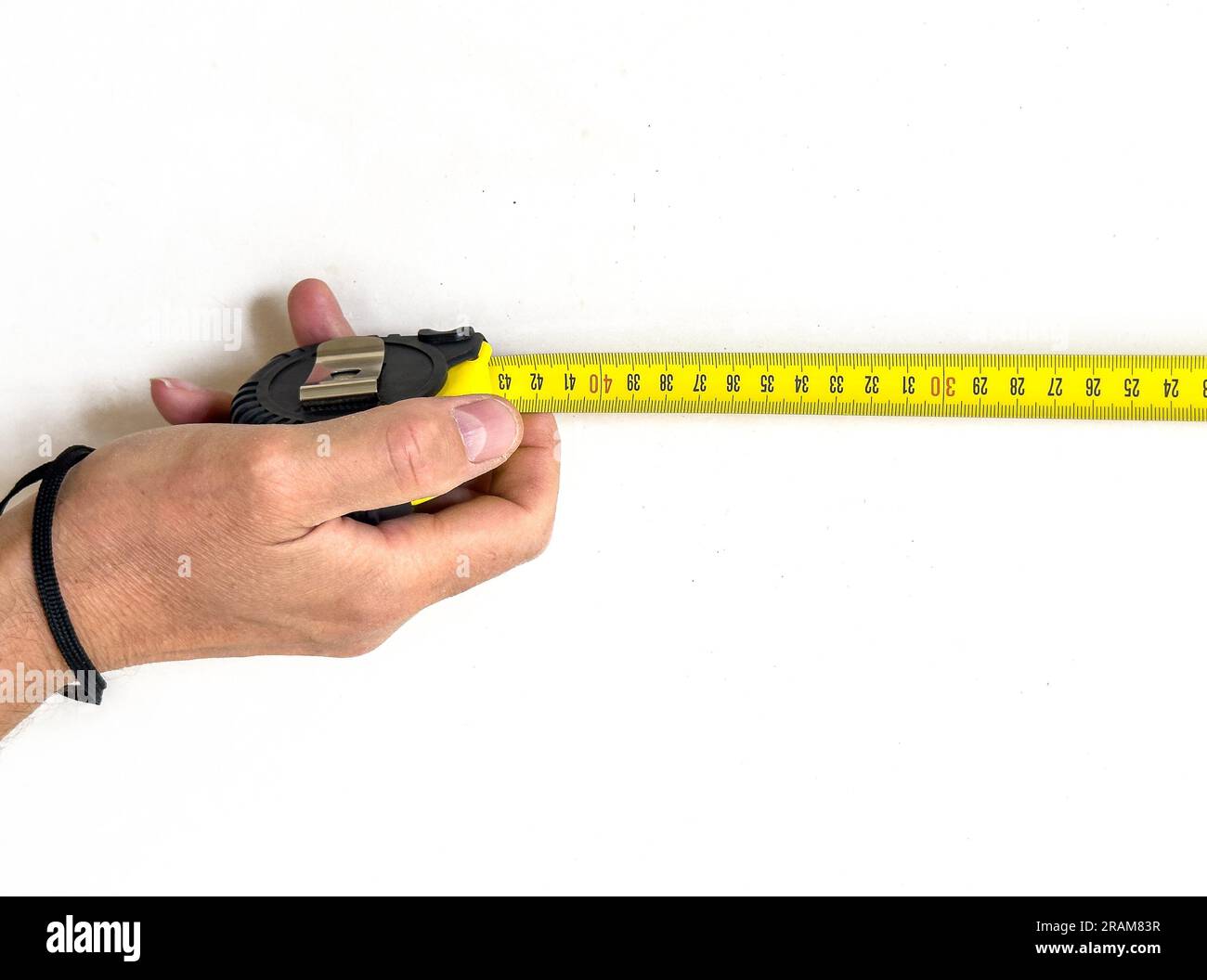 Hand holding measuring tool for house wall measurement Stock Photo - Alamy