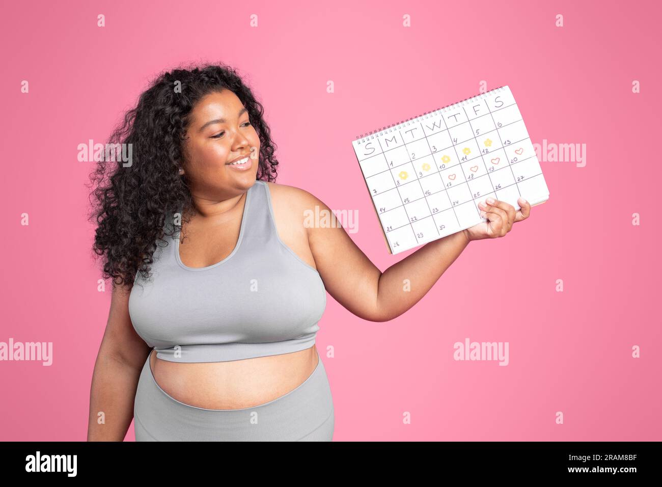 Sports and menstruation. Smiling black overweight woman in sportswear ...