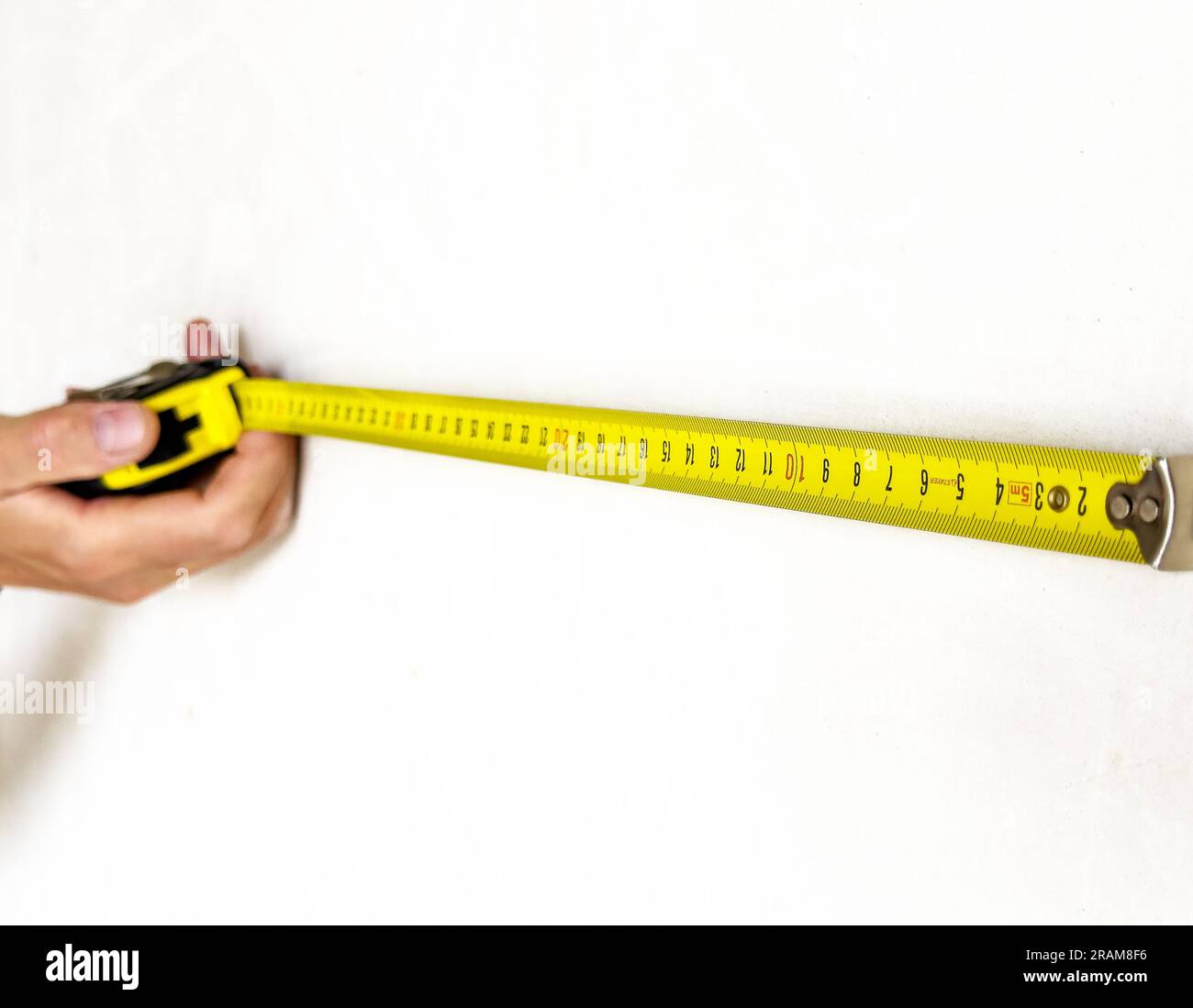 Hand holding measuring tool for apartment wall measurement Stock Photo ...