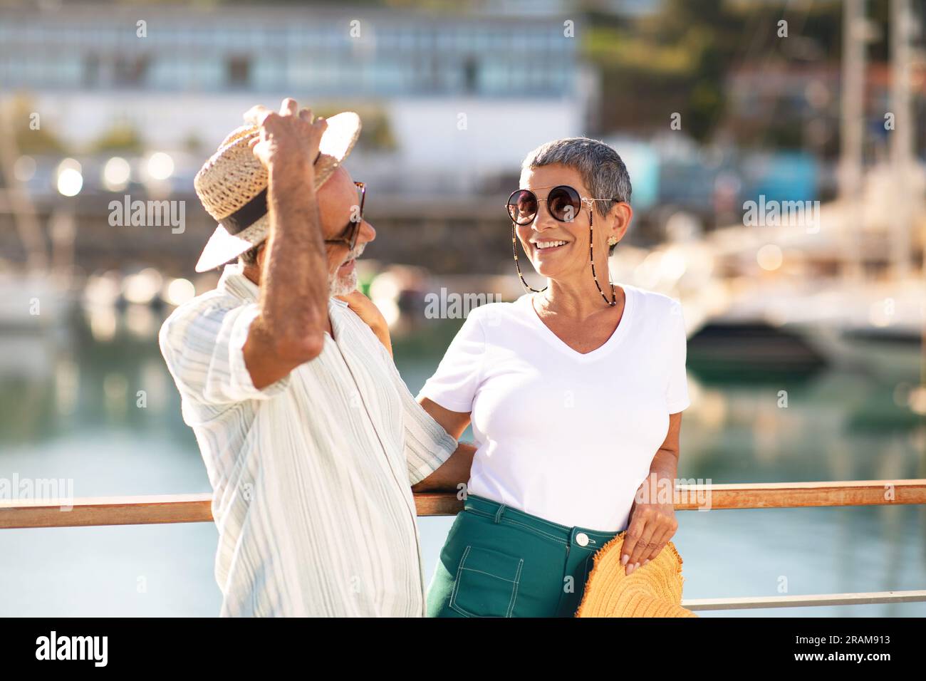 Senior Man Holding Straw Hat Hugging Wife At Marina Outdoor Stock Photo ...